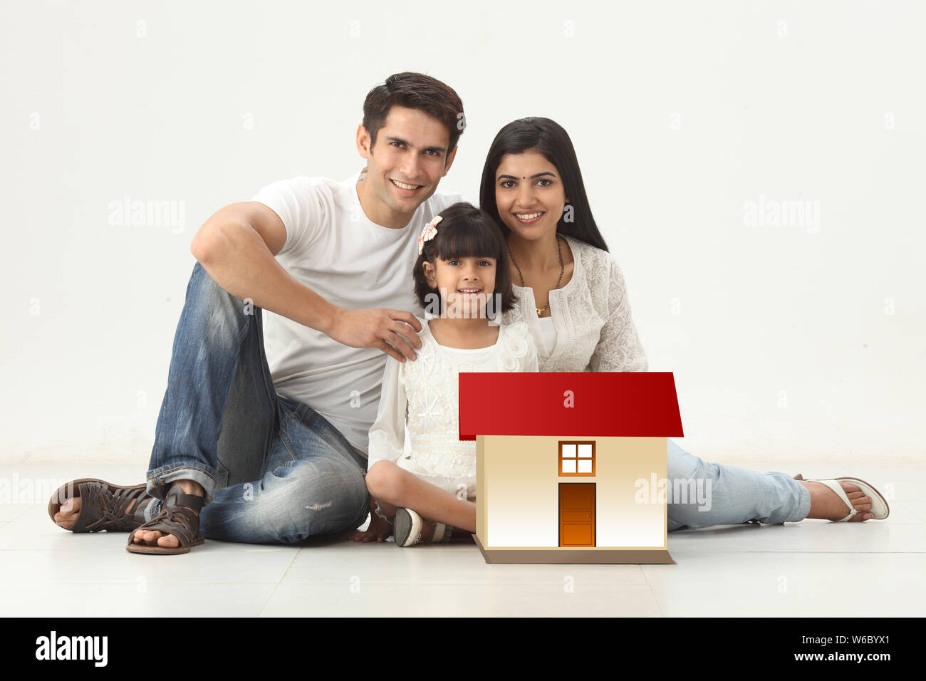 Family sitting with model of dream home Stock Photo - Alamy