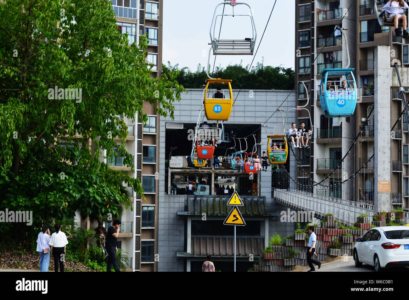 Tourists take cable cars on a cableway going through an entertainment ...