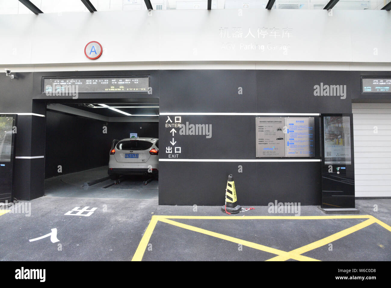 An automated guided vehicle (AGV) robot transfers a car into a parking ...