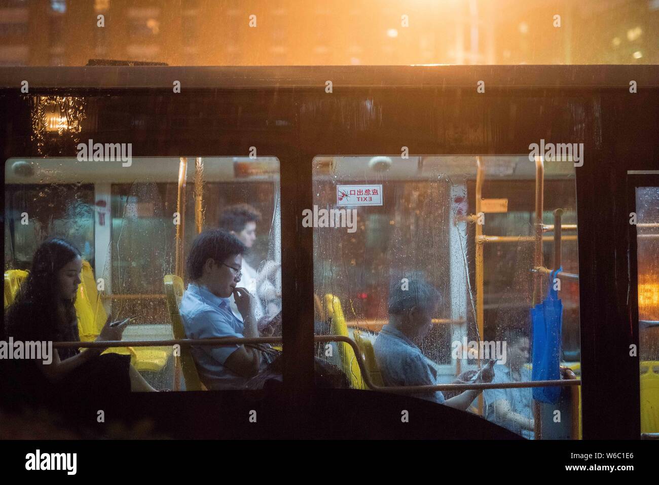 Local residents take a bus in a heavy rainstorm in Guangzhou city ...