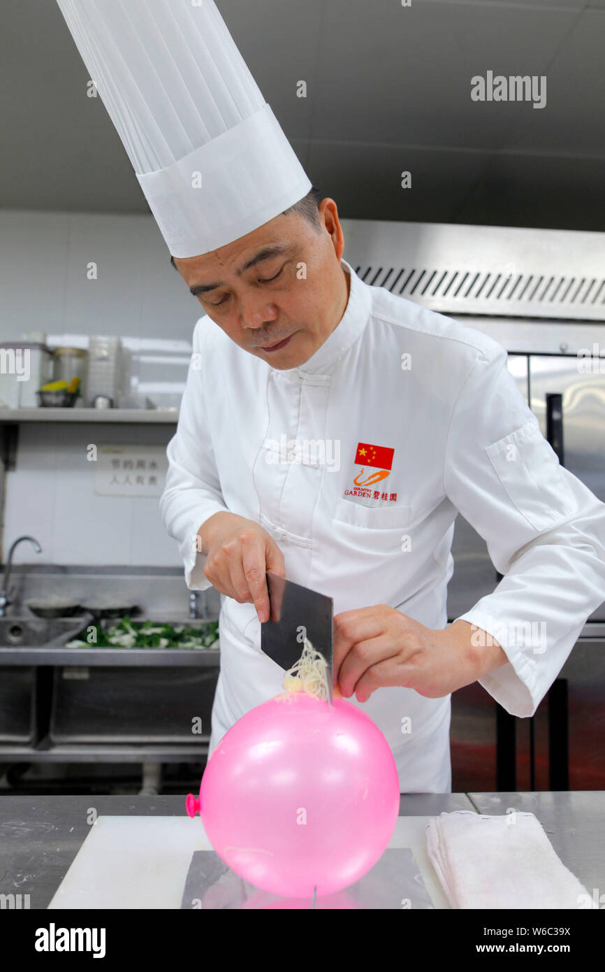 Cantonese chef Lin Chaodai is cutting a potato slice perched on a ...