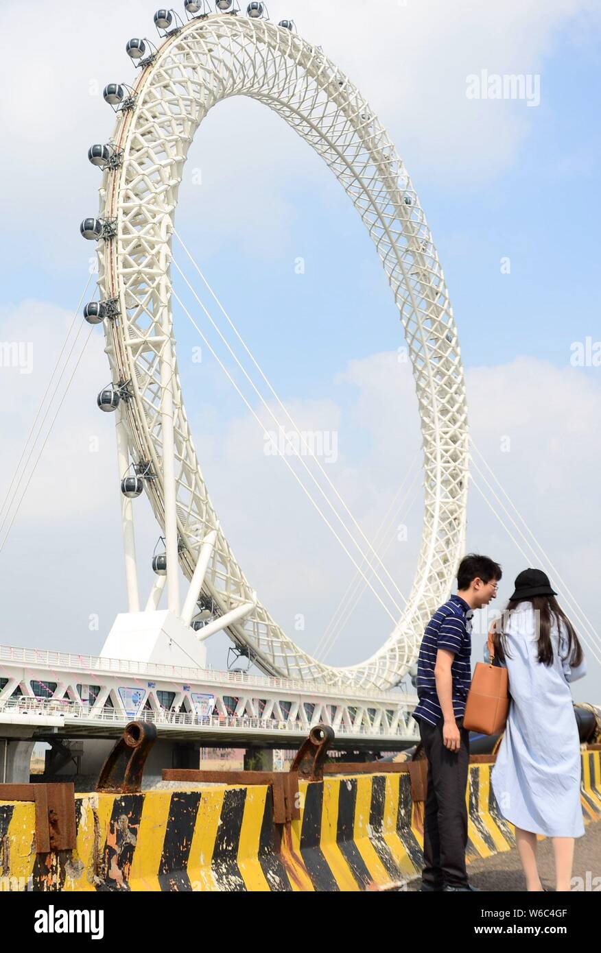 People visit Bailang River Bridge Ferris Wheel, the world's largest spokeless Ferris wheel with ...