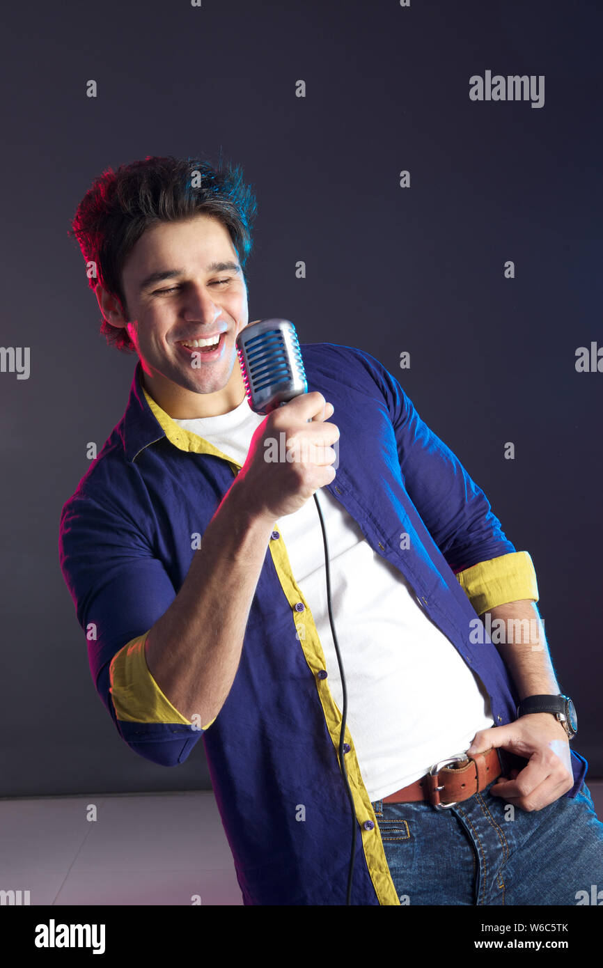 Man singing into microphone and smiling Stock Photo - Alamy