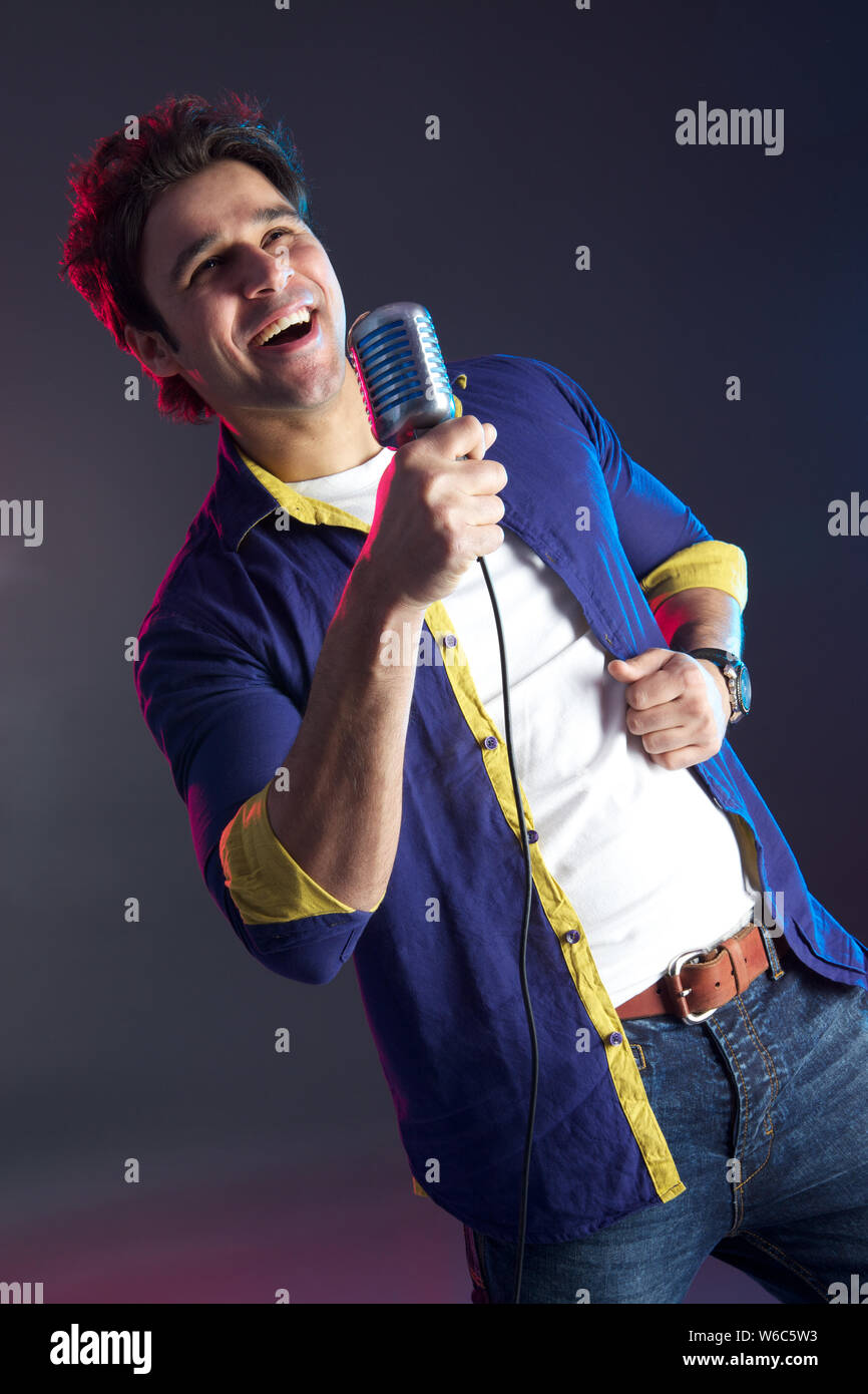 Man singing into microphone and smiling Stock Photo - Alamy