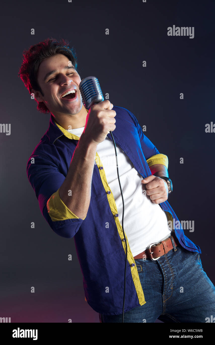 Man singing into microphone and smiling Stock Photo - Alamy