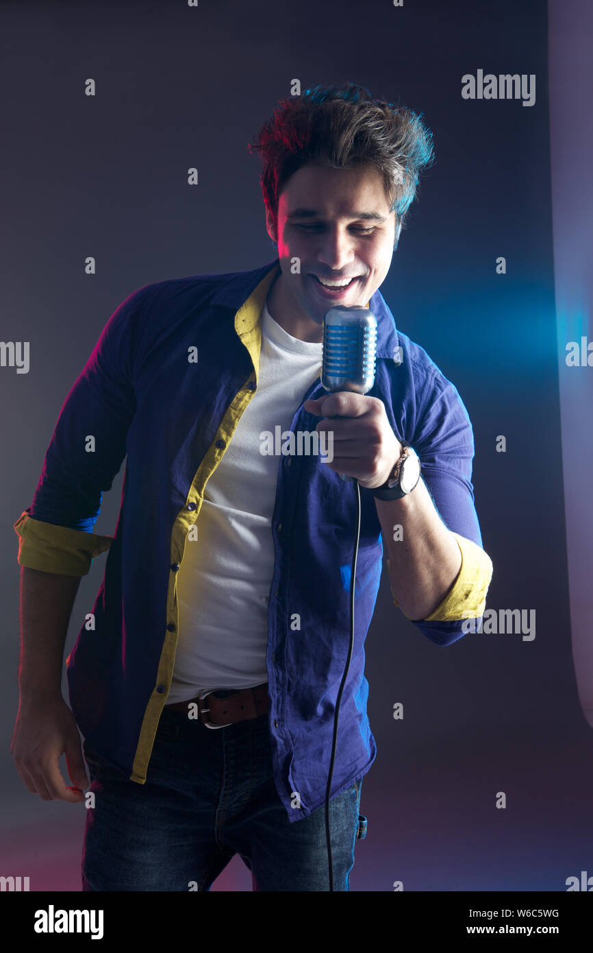Man singing into microphone and smiling Stock Photo - Alamy