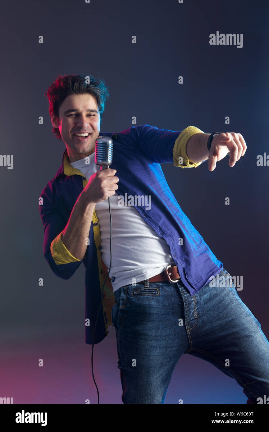 Man singing into microphone Stock Photo - Alamy