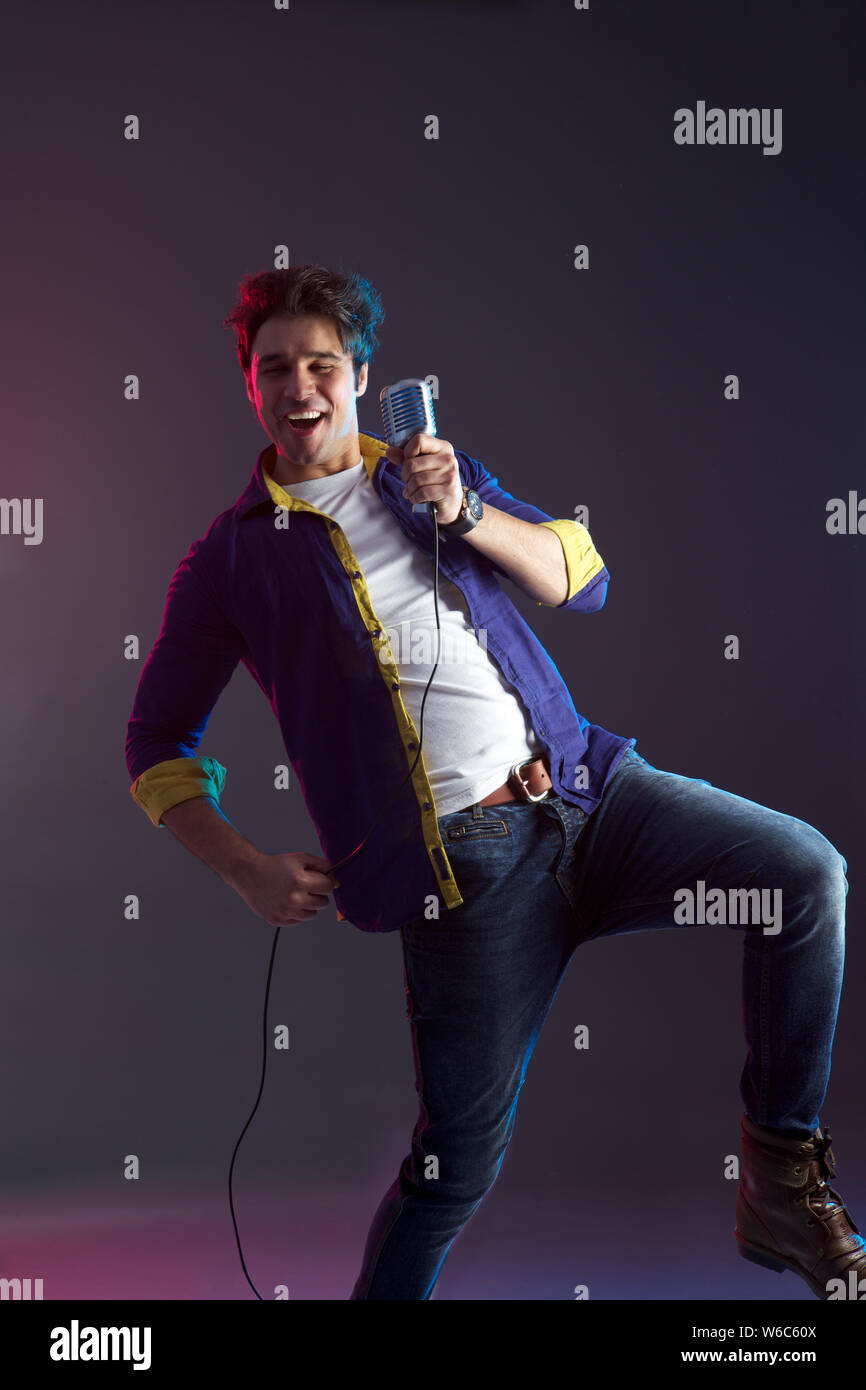 Man singing into microphone Stock Photo - Alamy