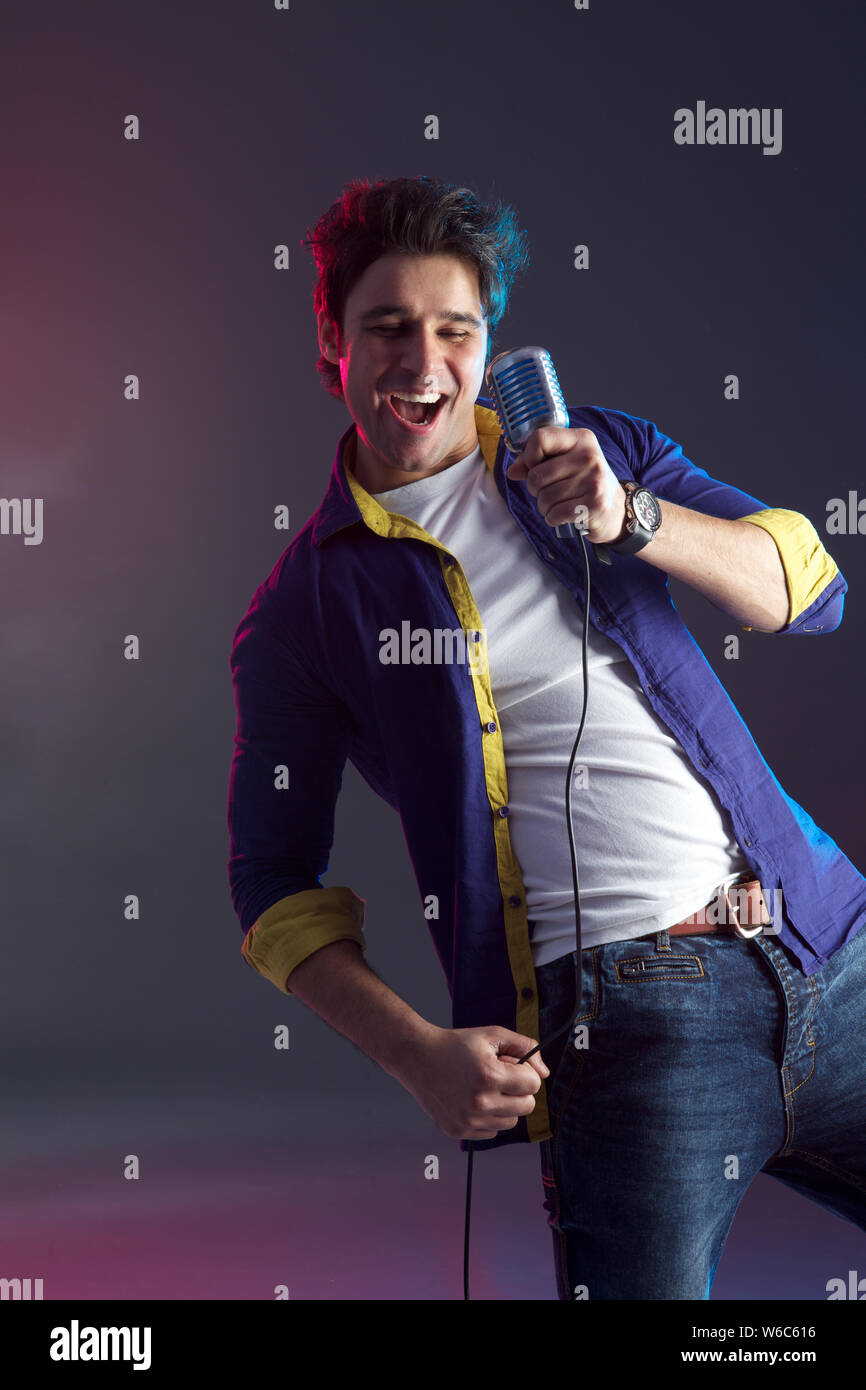 Man singing into microphone Stock Photo - Alamy