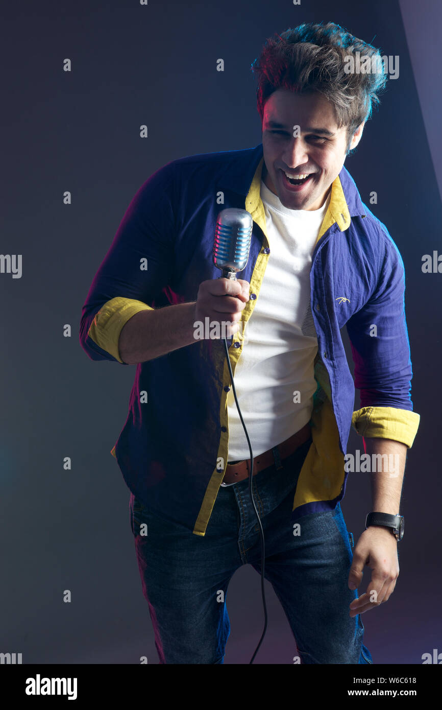 Man singing into microphone Stock Photo - Alamy