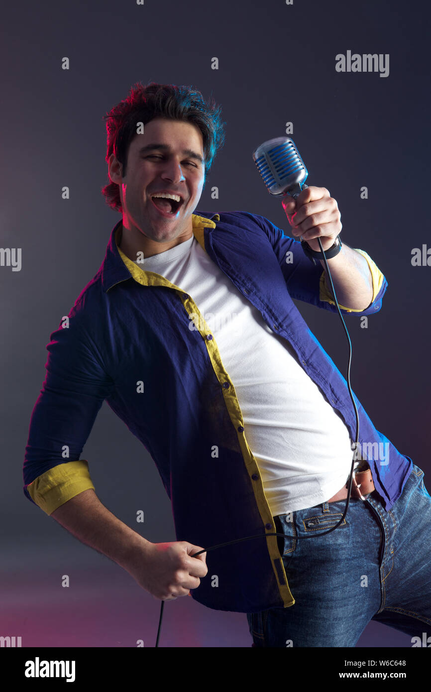 Man singing into microphone Stock Photo - Alamy