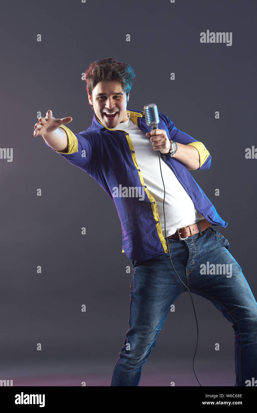 Man singing into microphone Stock Photo - Alamy