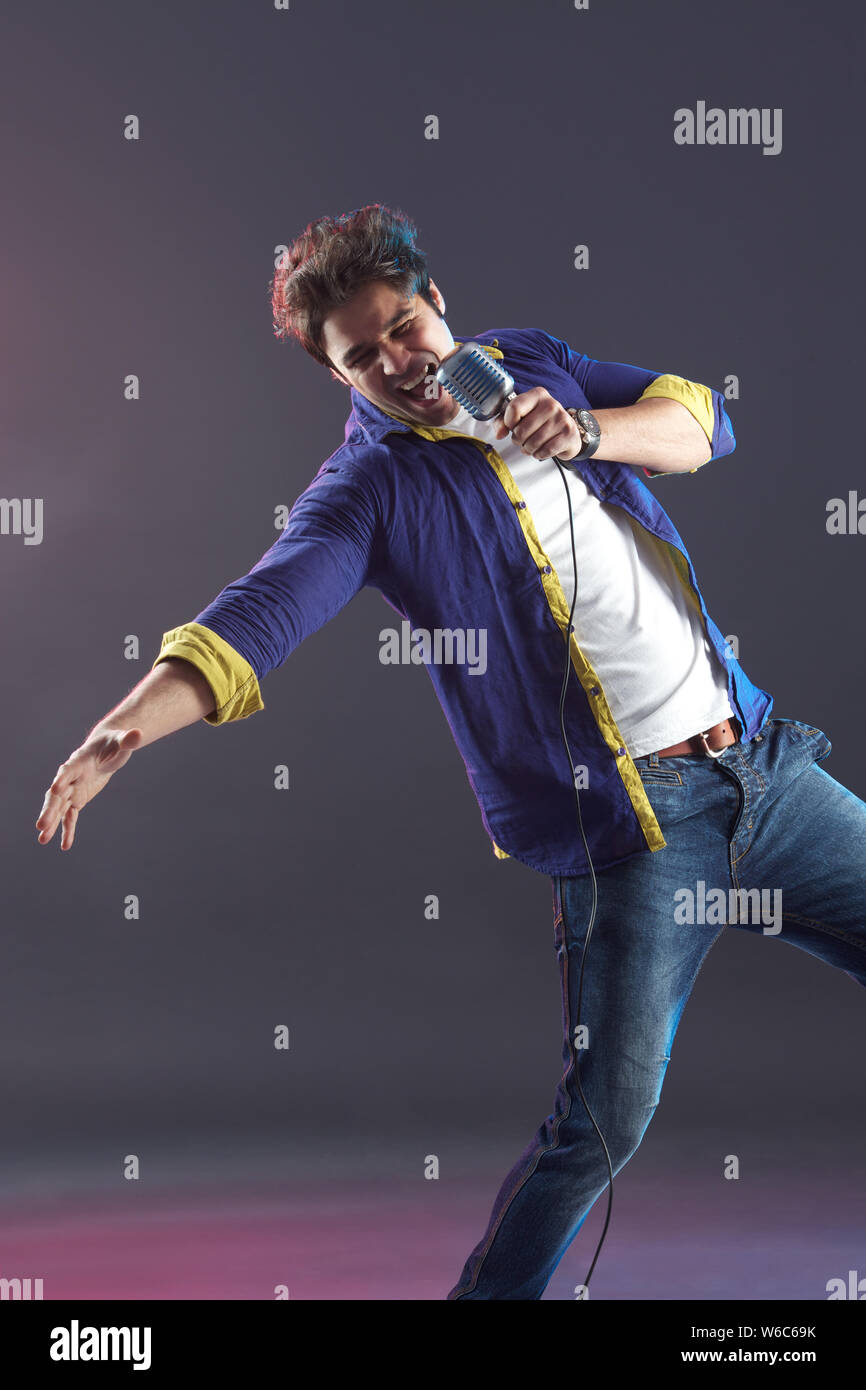 Man singing into microphone Stock Photo - Alamy