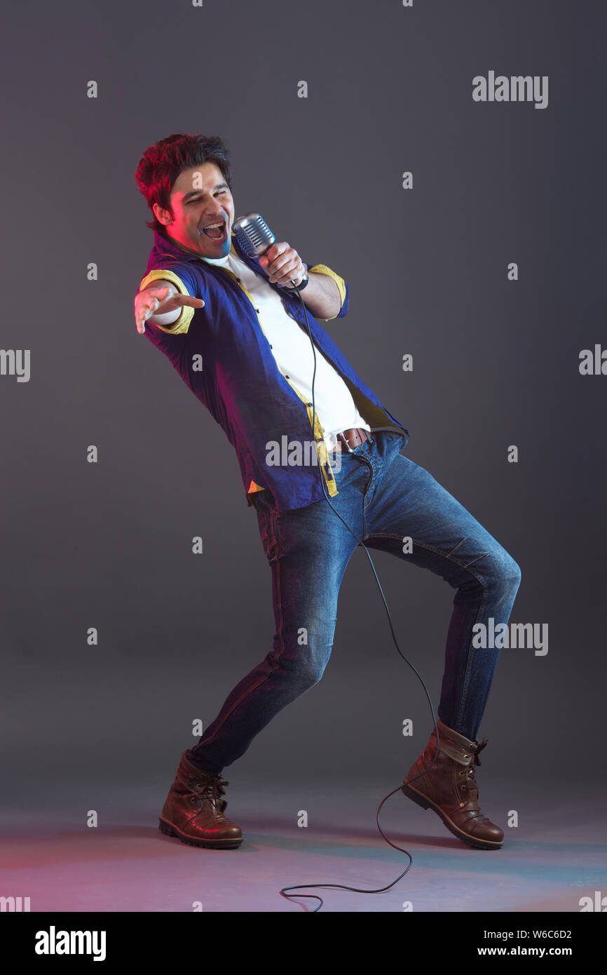 Man singing into microphone Stock Photo - Alamy