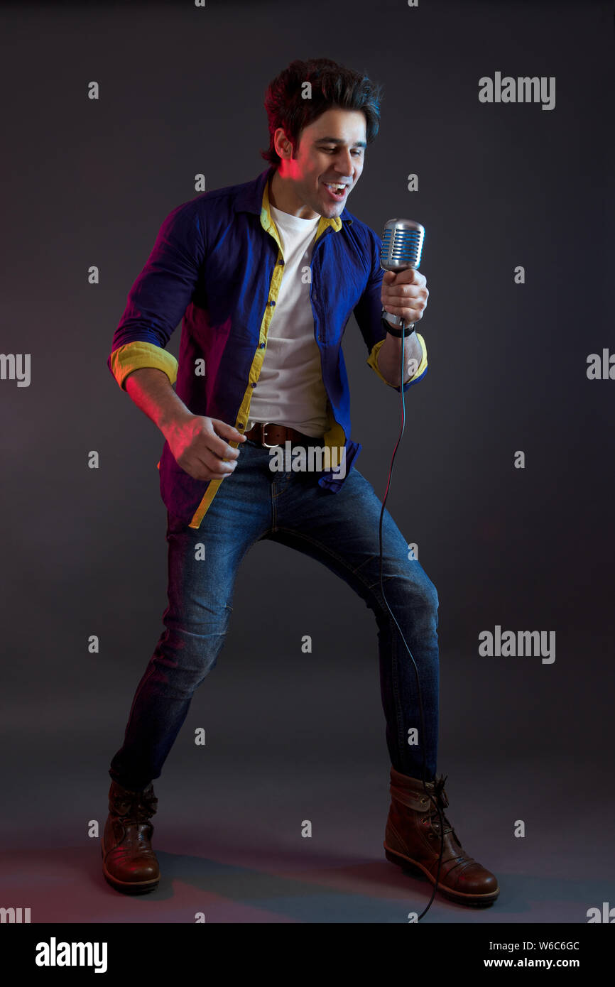 Man singing into microphone Stock Photo - Alamy