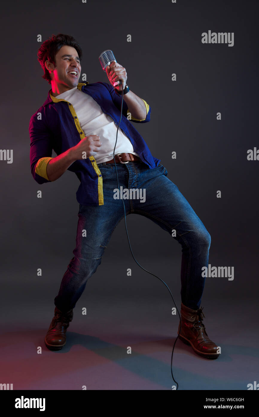 Man singing into microphone Stock Photo - Alamy