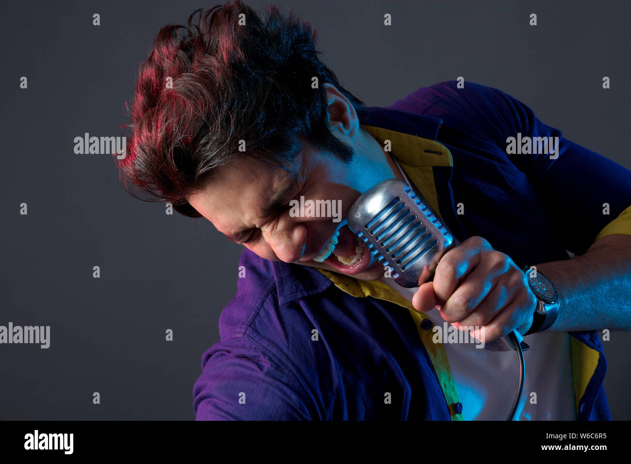 Man singing into microphone Stock Photo - Alamy