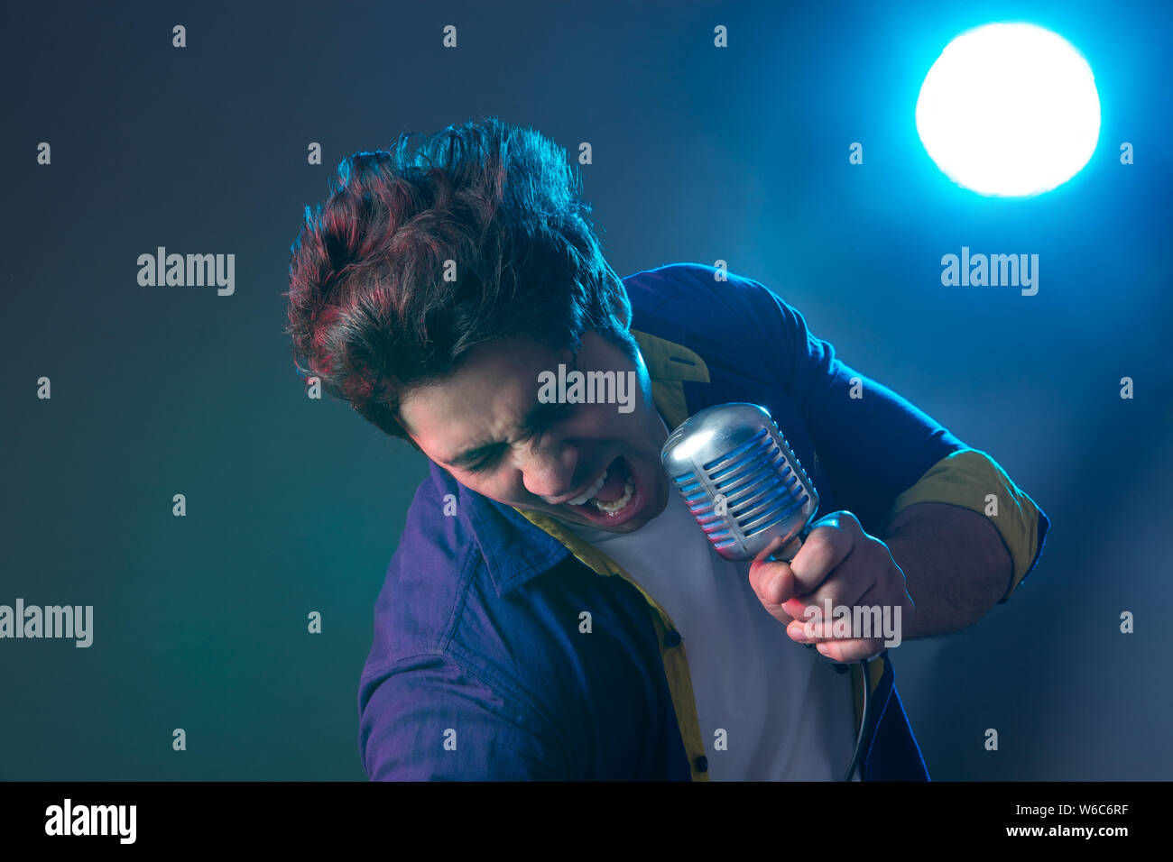 Man singing into microphone Stock Photo - Alamy