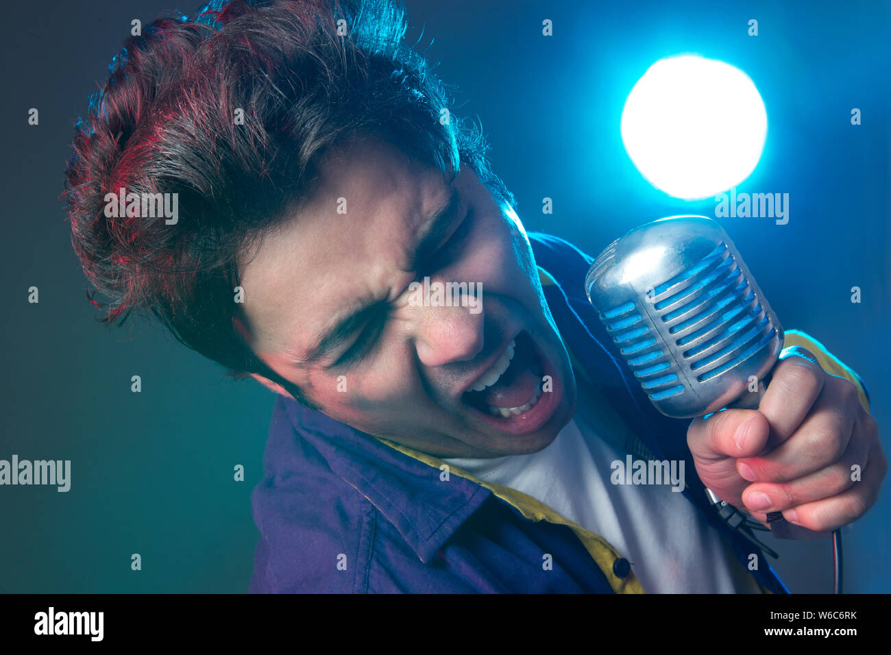Man singing into microphone Stock Photo - Alamy