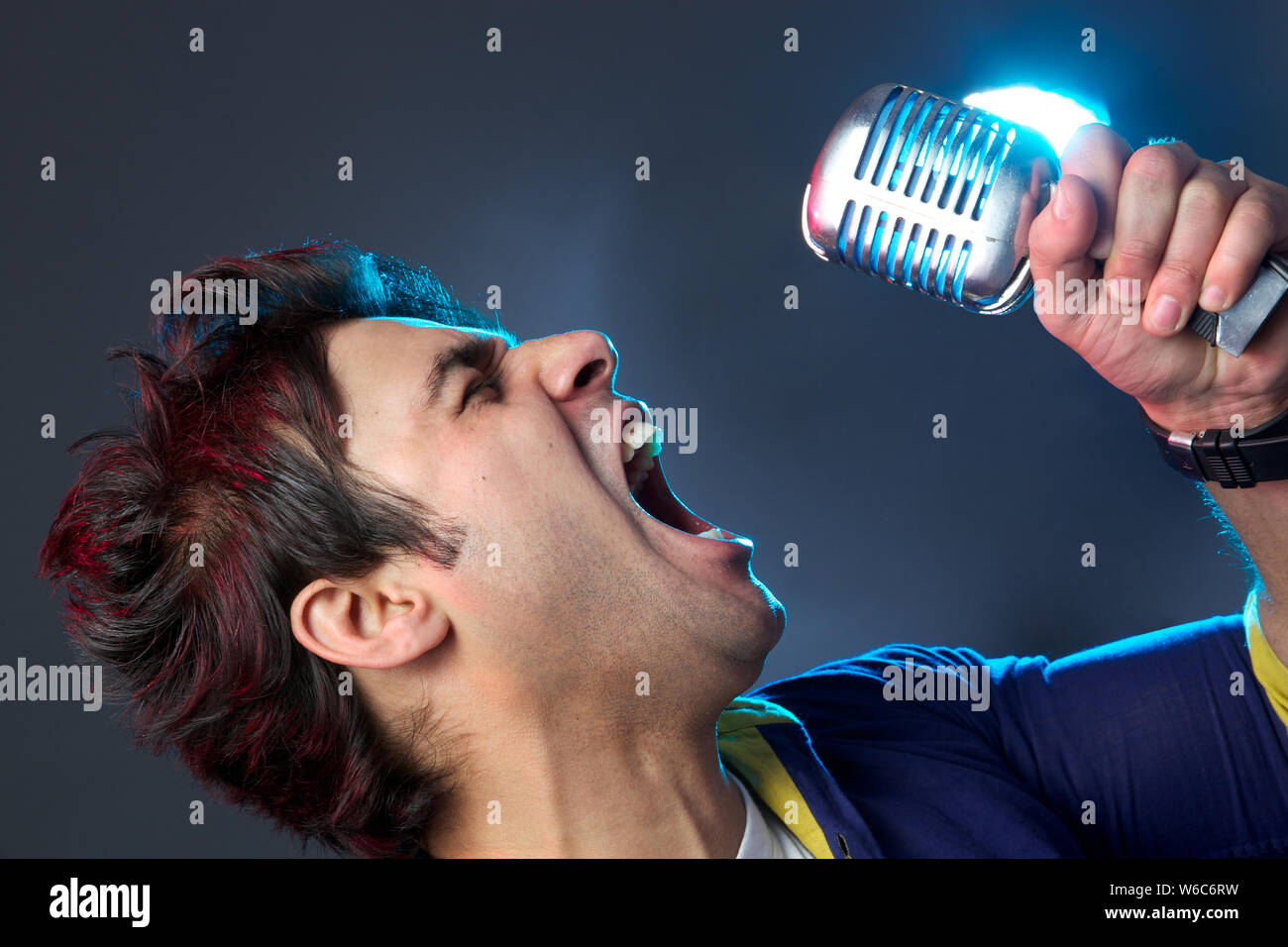 Man singing into microphone Stock Photo - Alamy