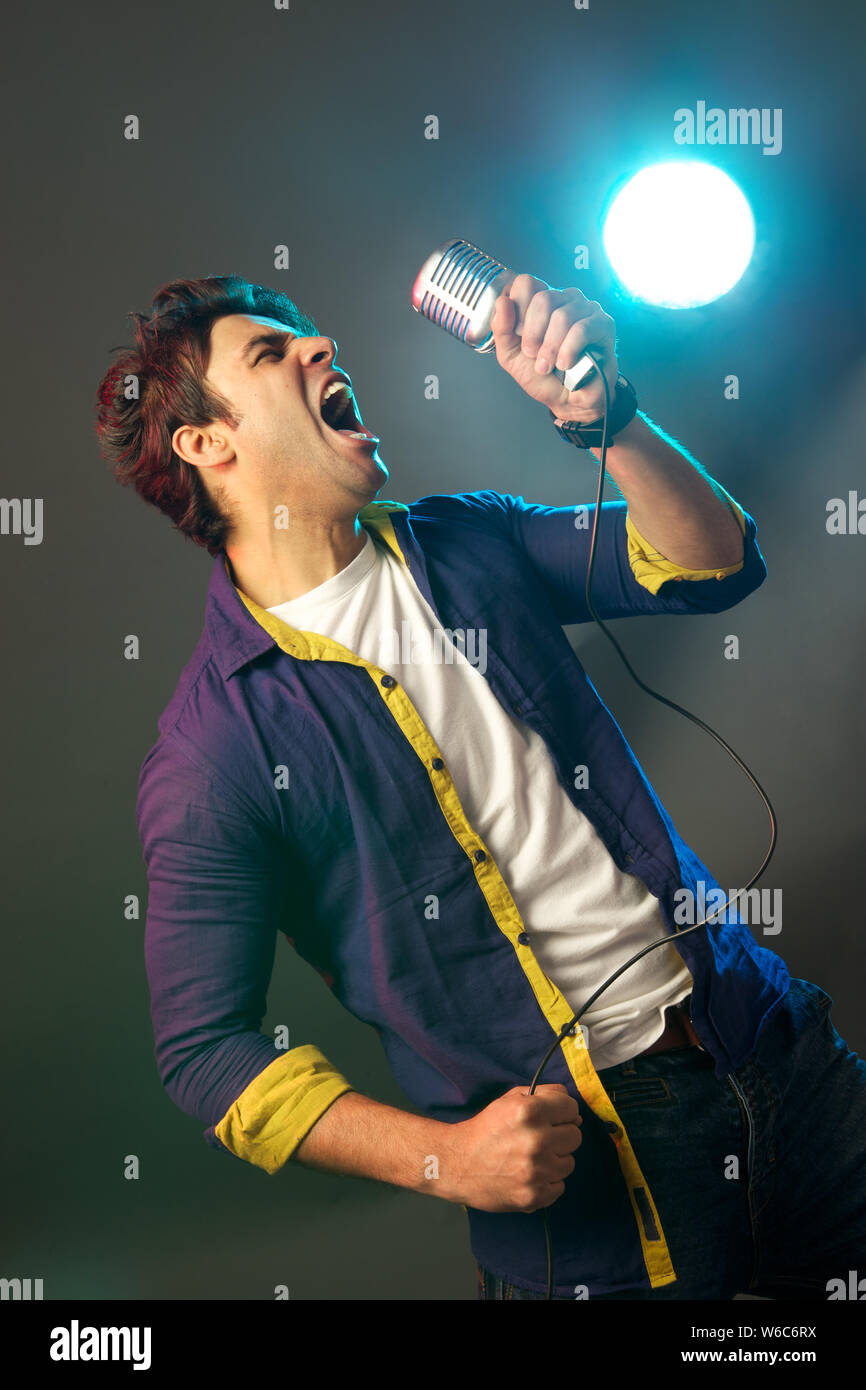 Man singing into microphone Stock Photo - Alamy