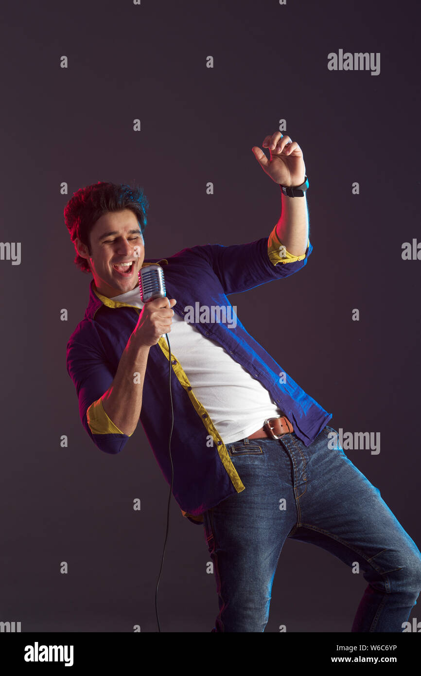 Man singing into microphone Stock Photo - Alamy