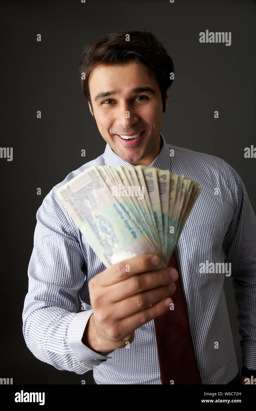 Businessman holding one hundred rupees banknotes Stock Photo - Alamy