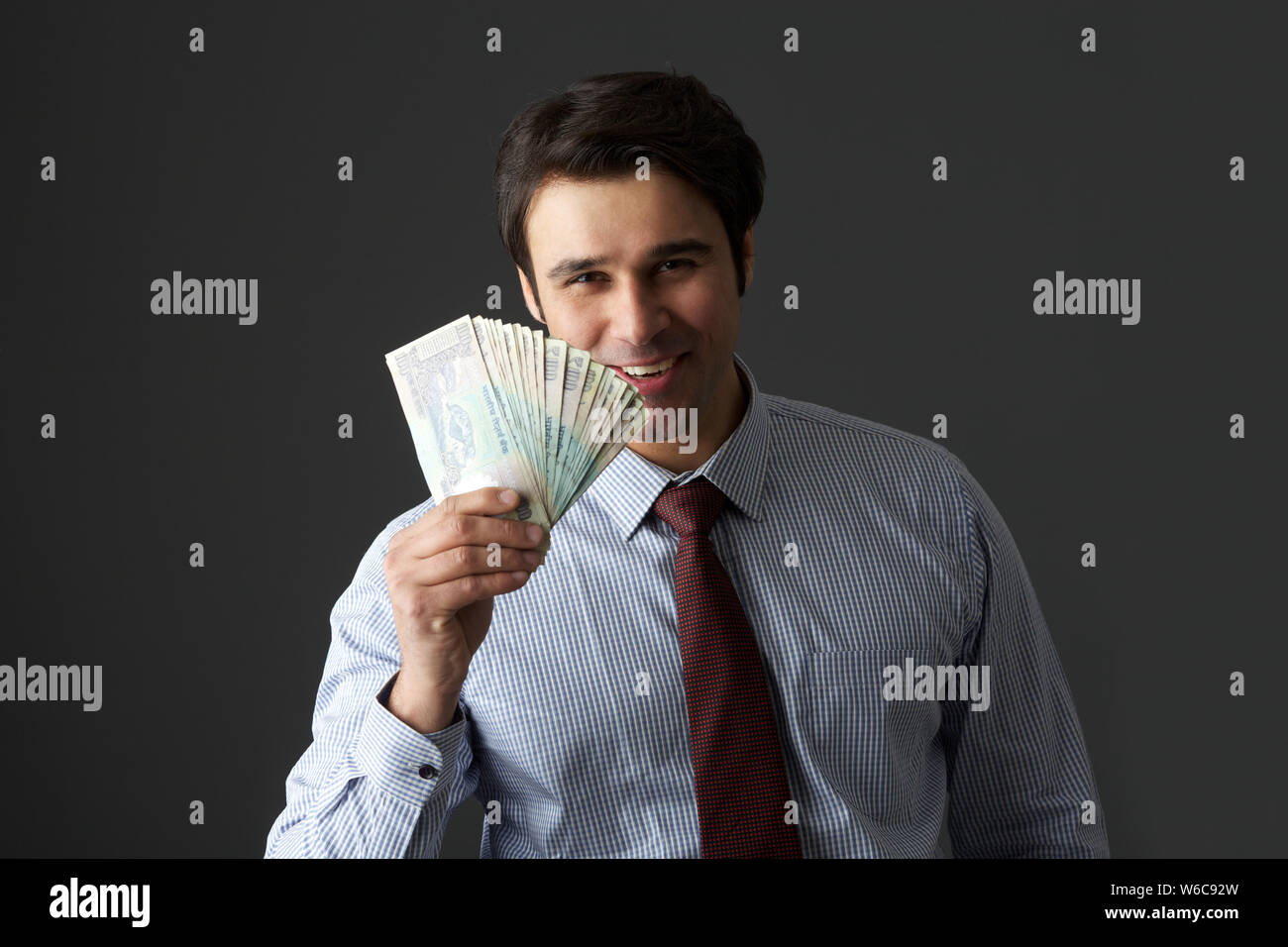 Businessman holding one hundred rupees banknotes Stock Photo - Alamy