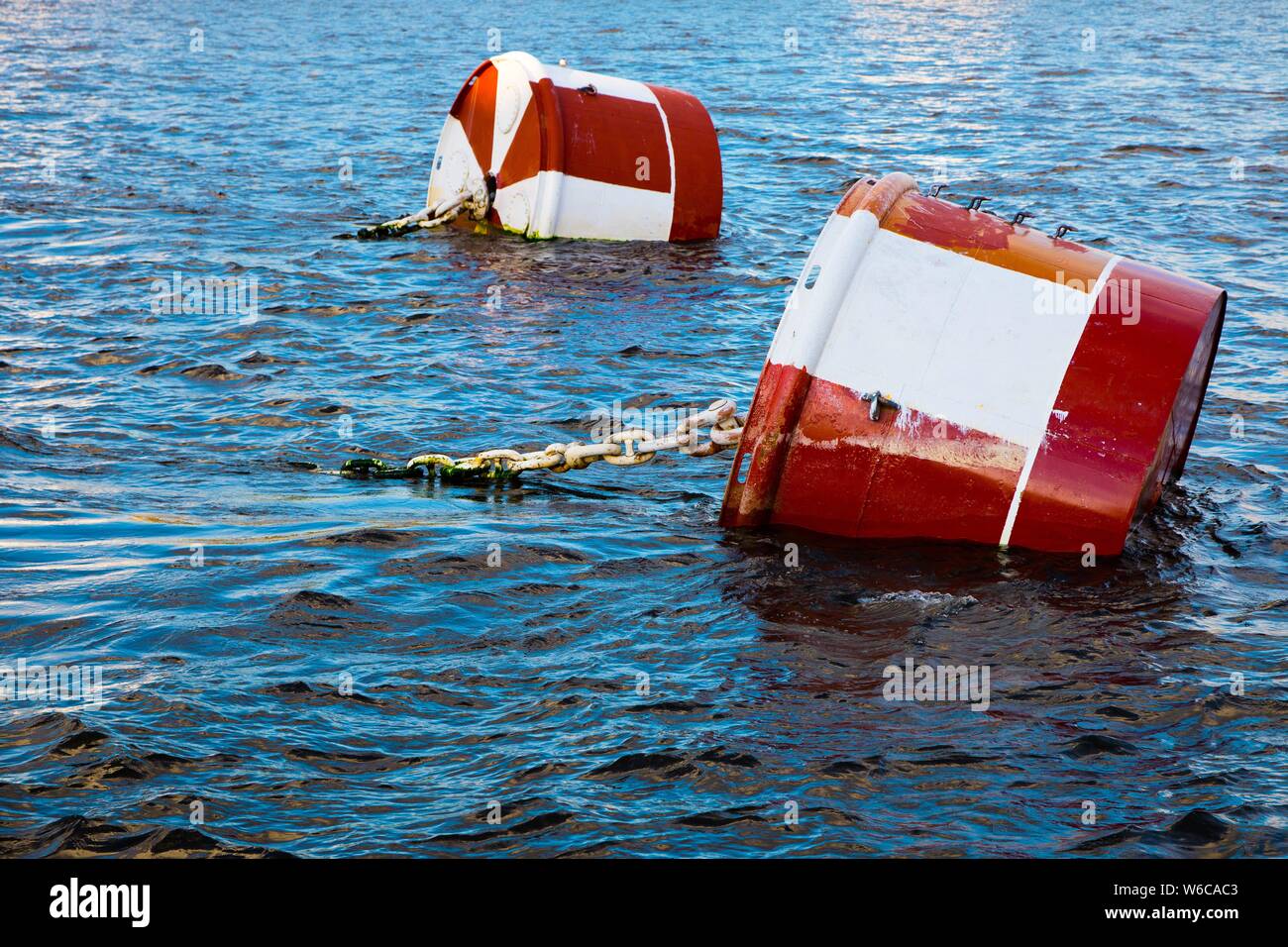 Two big red-white buoys in the middle of the water surface to anchor ...