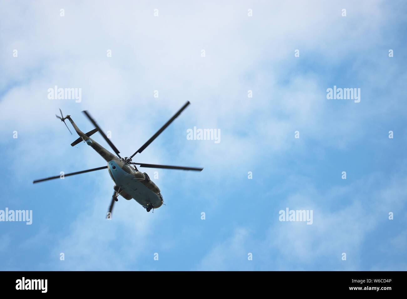 Military helicopter in flight on background of blue sky with white ...