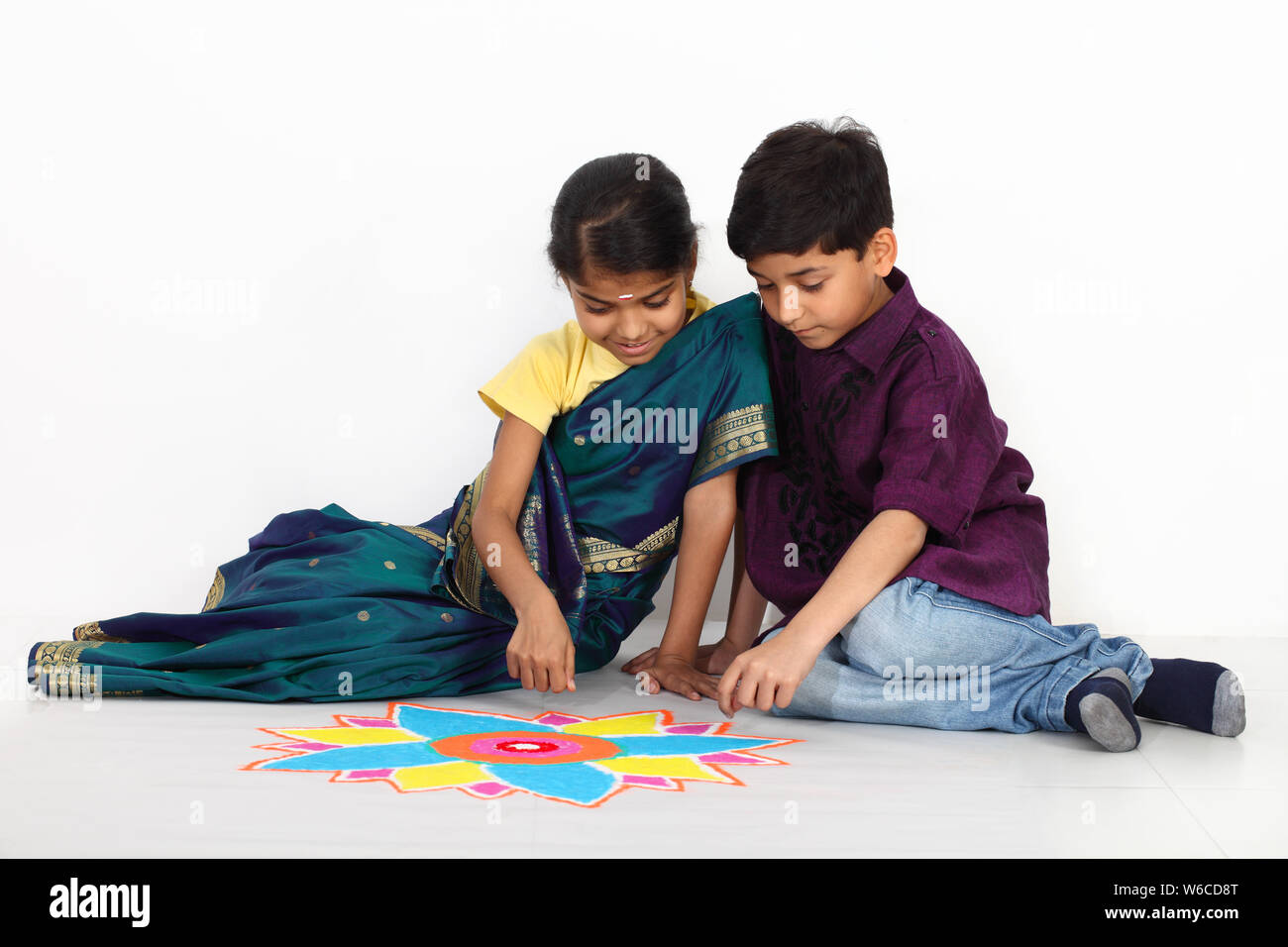 Kids dressed as couple making a rangoli Stock Photo - Alamy