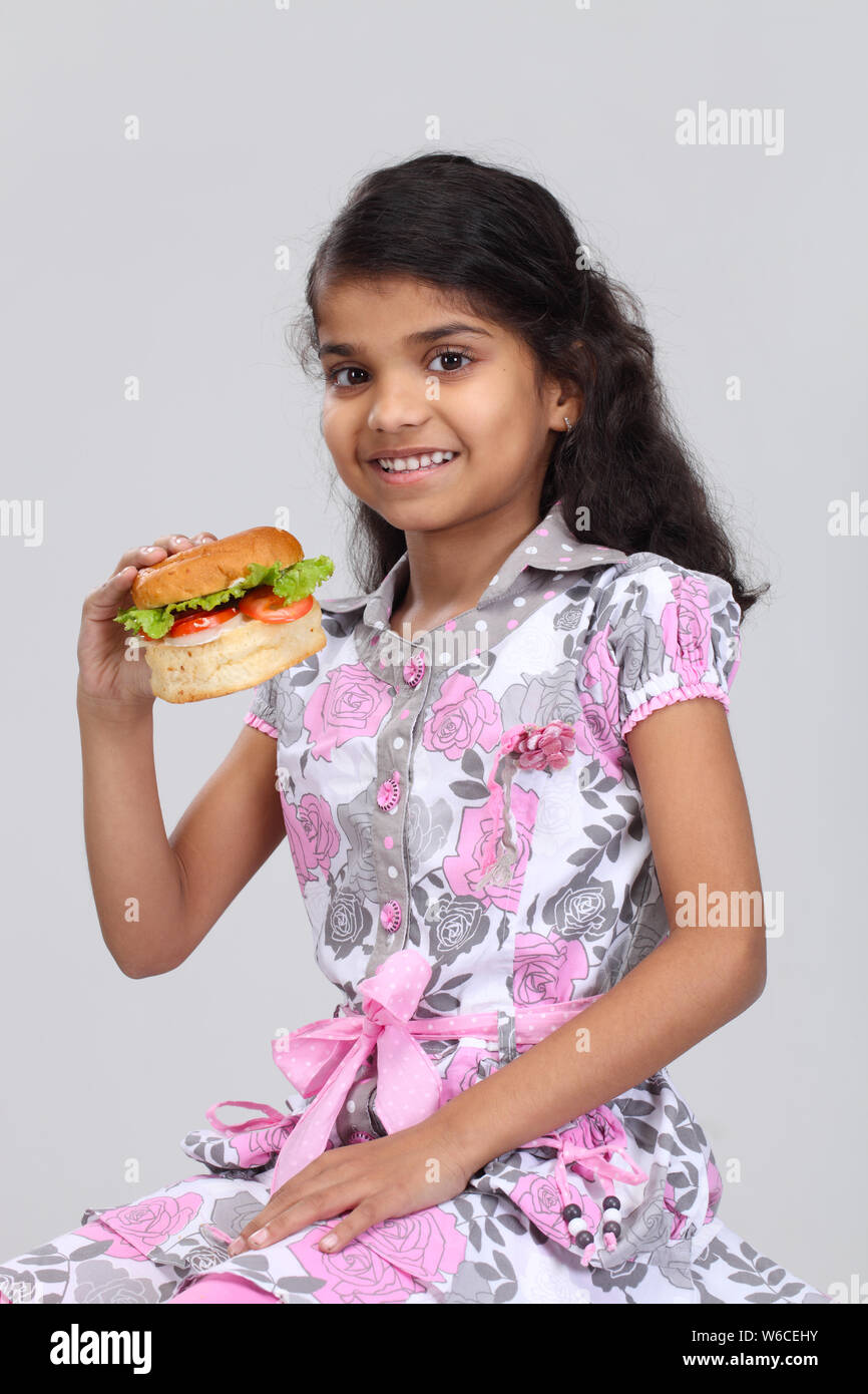 Girl eating a burger Stock Photo - Alamy