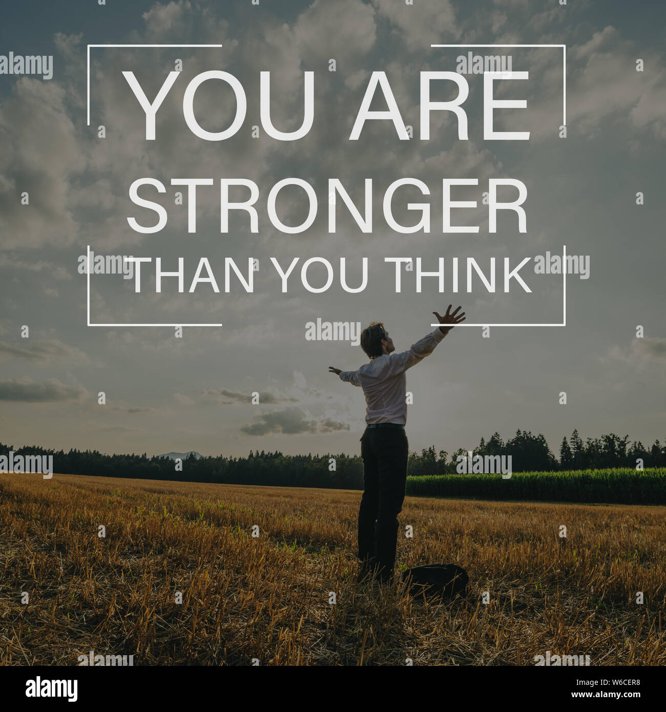 You are stronger than you think sign over a businessman standing in ...