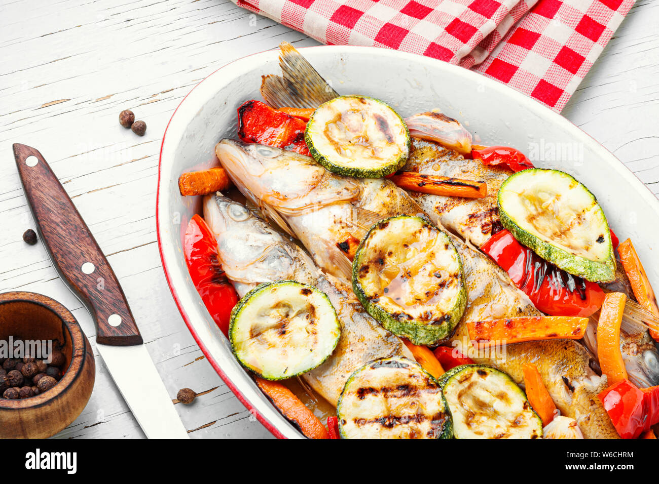 Baked fish with vegetable garnish.Baked pike perch with zucchini and ...