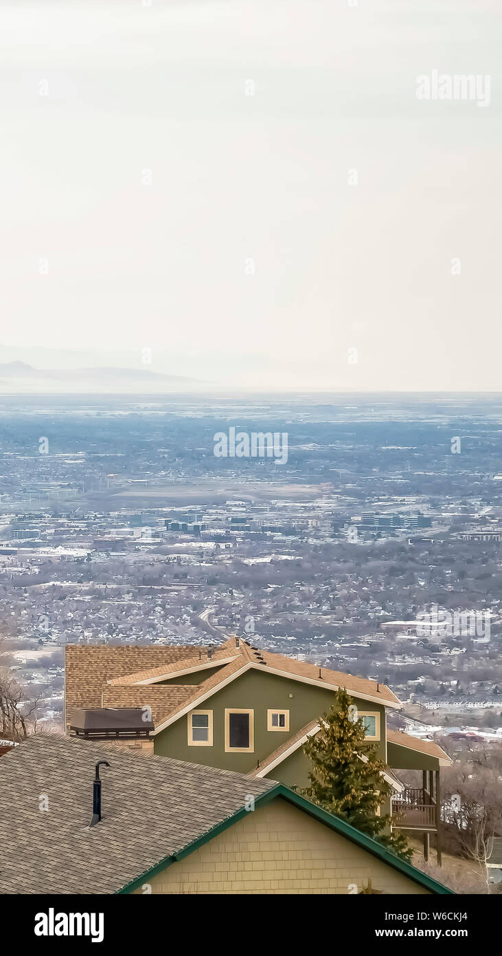 Vertical frame Rooftops of homes with cloudy sky mountain and vast ...