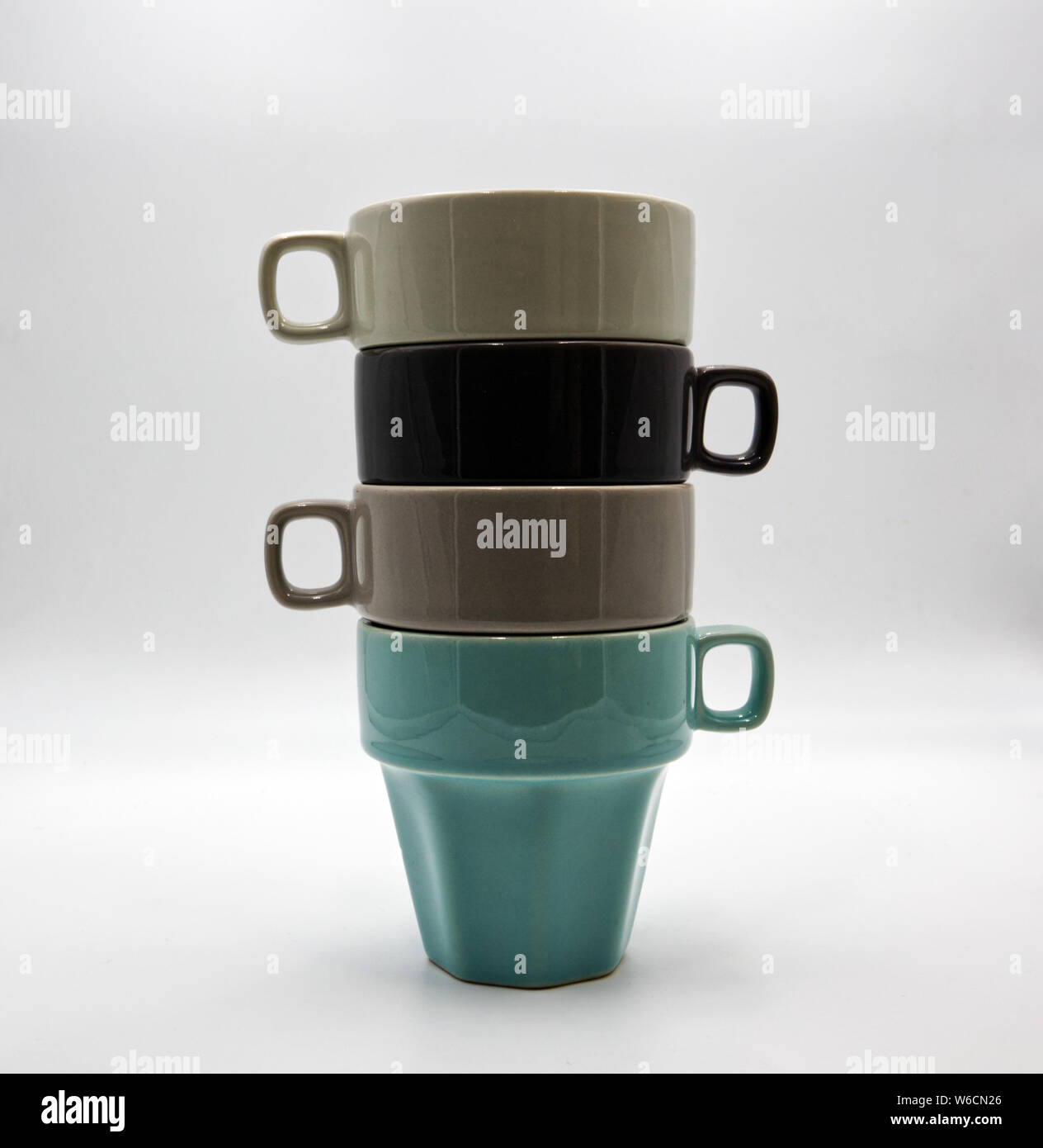 Pile of colored mugs isolated on white background Stock Photo - Alamy