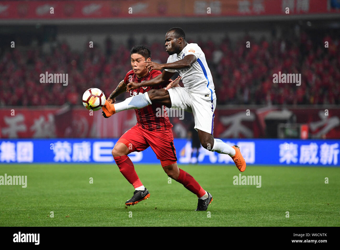 Cai Huikang of Shanghai SIPG, left, challenges Ghanaian football player ...