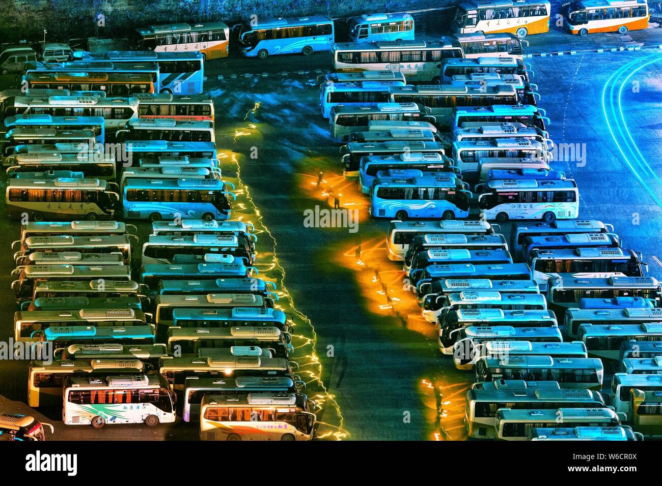 Night view of passenger buses parked at a long-distance bus station in ...