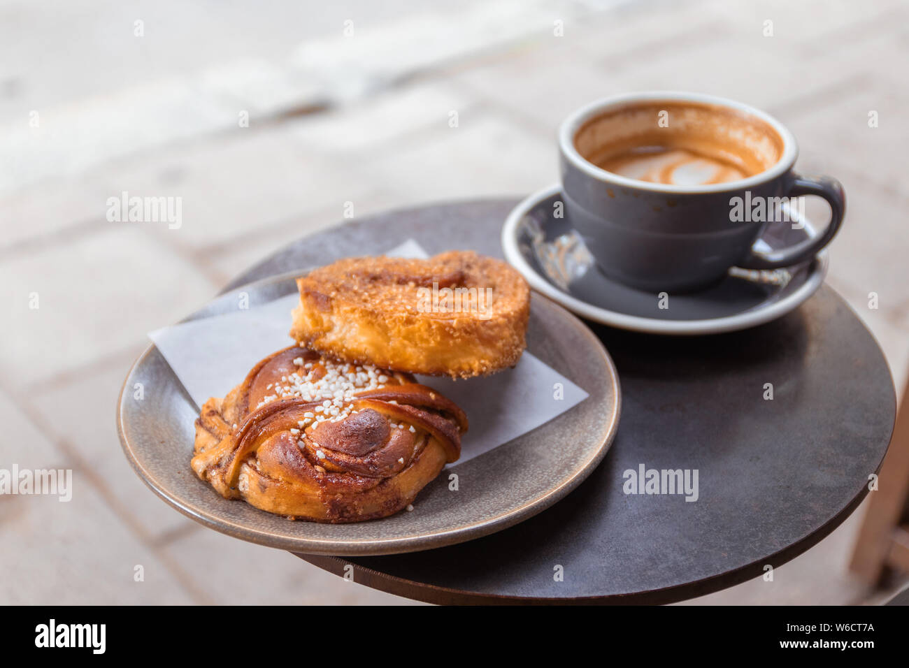 Cup of coffee and bun with cinnamon lying on the table in cafe Stock ...