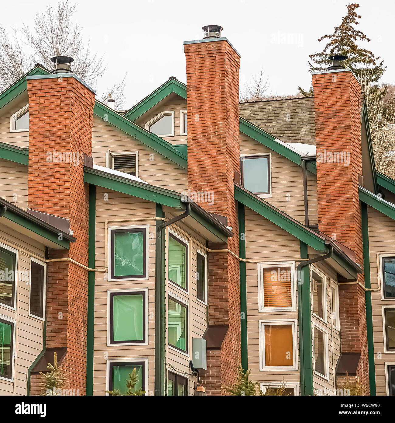 Square Homes with white wall sidings and red brick chimneys against ...