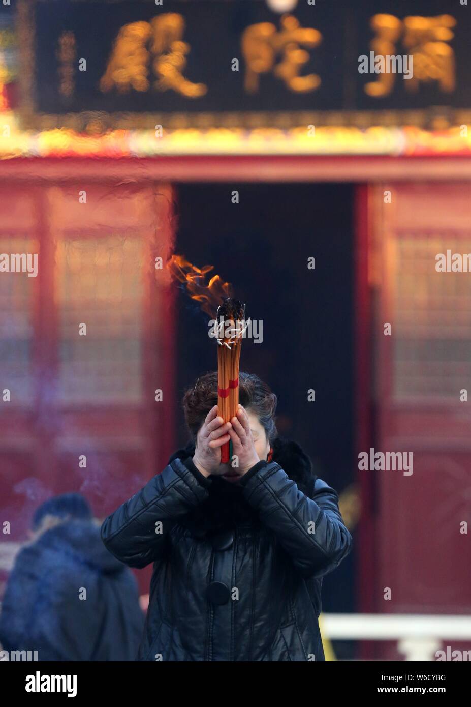 --FILE--A Chinese worshipper burns incense sticks to pray for good luck ...