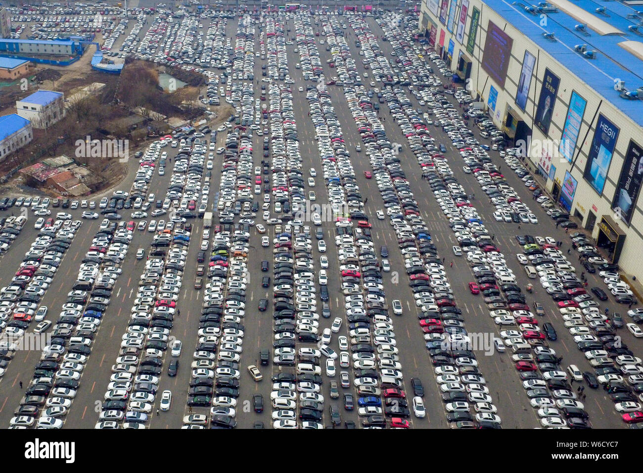 Aerial view of masses of vehicles at a parking lot of a shopping mall ...