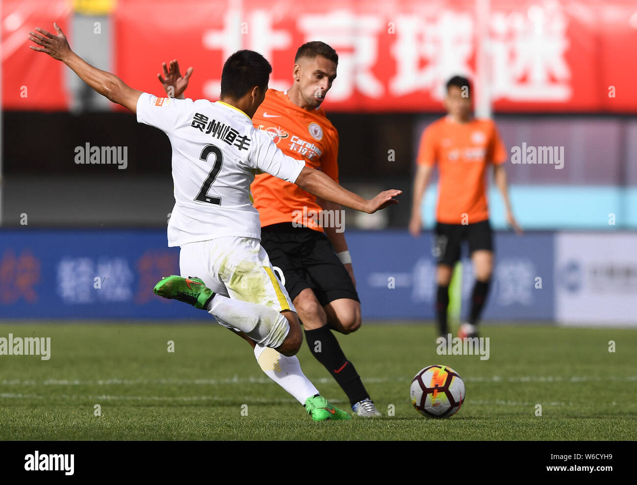 Brazilian football player Ivo of Beijing Renhe, back, dribbles the ball ...