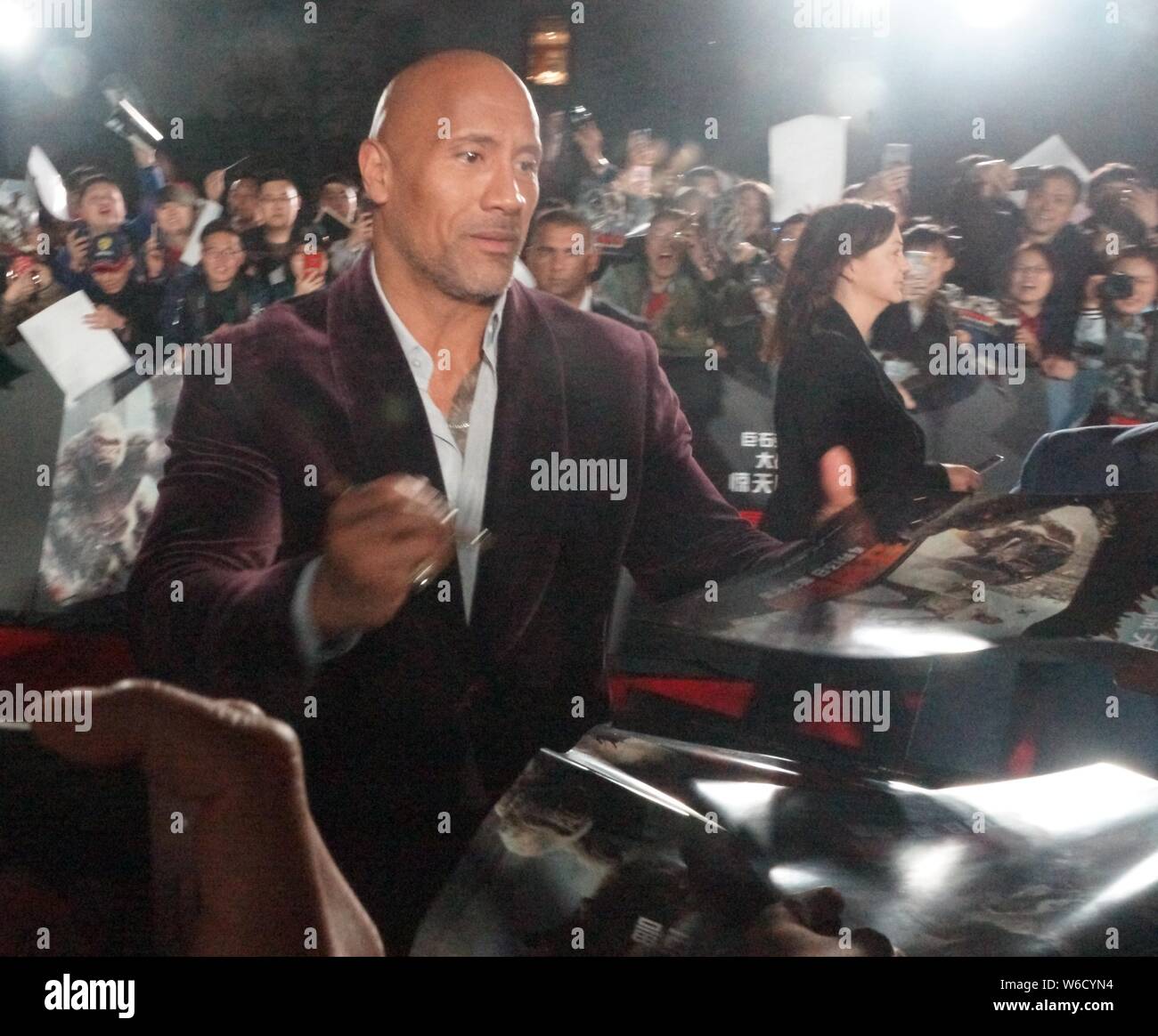 American actor Dwayne Johnson signs autographs for fans as he arrives ...