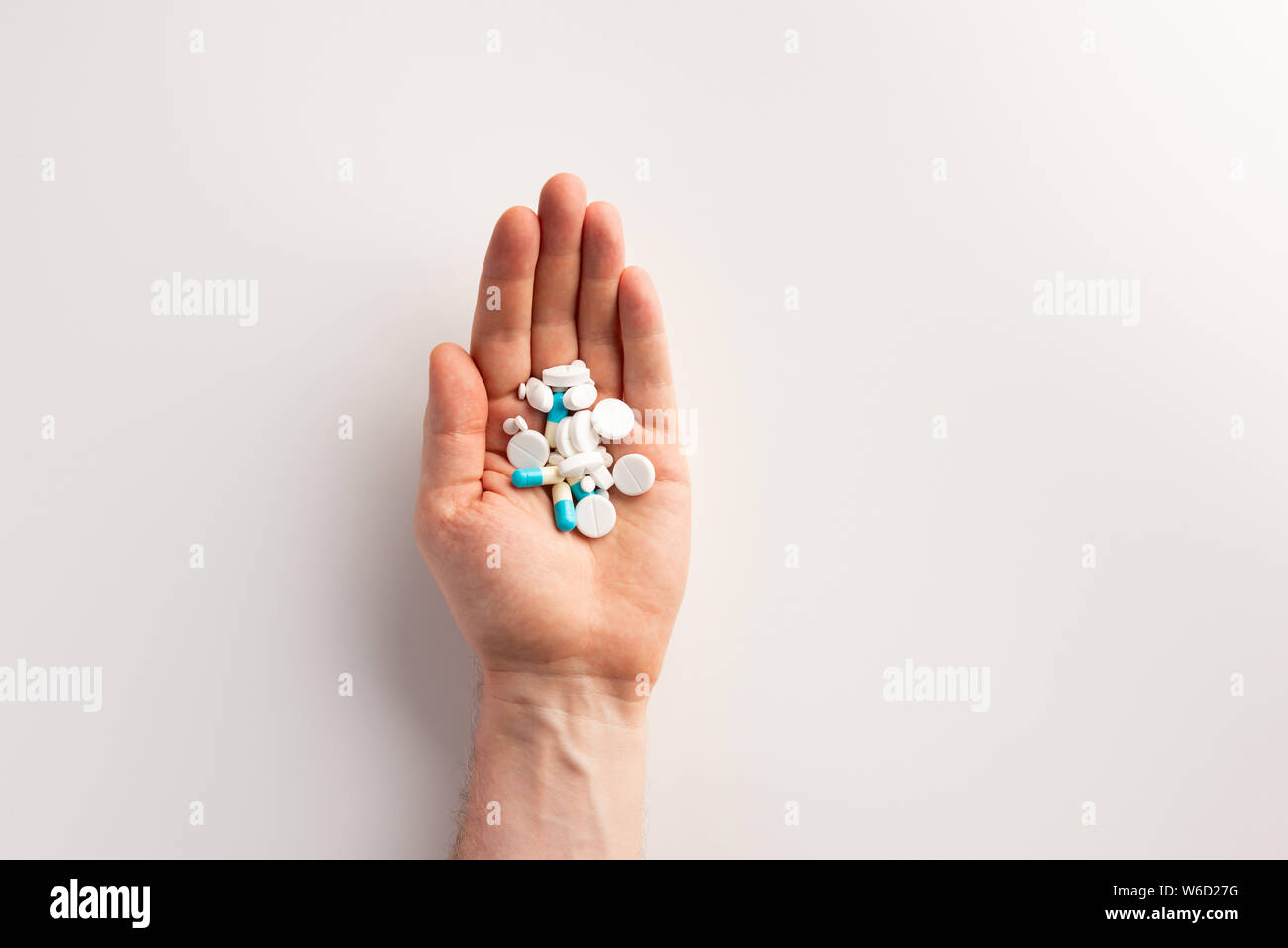 Pills in hand, on white background. Flat lay Stock Photo - Alamy