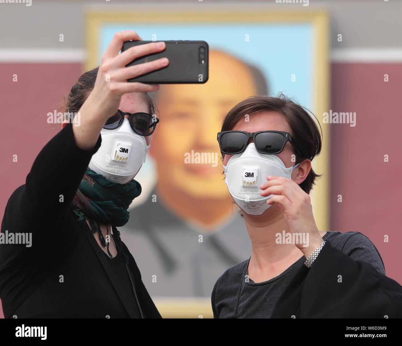 Foreign tourists wearing face masks against air pollution visit the ...