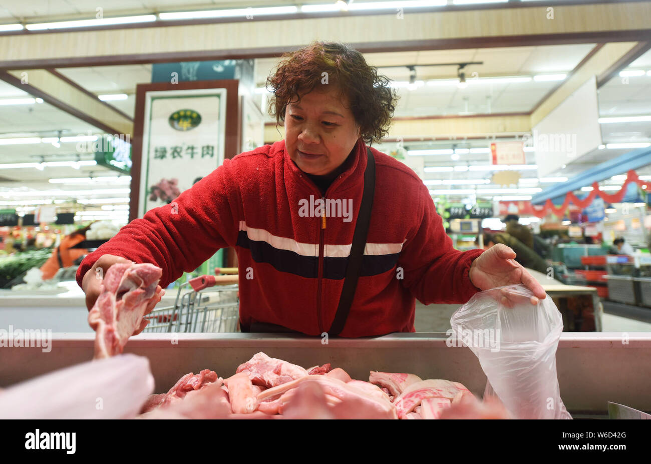 --FILE--A Chinese customer shops for pork at a supermarket in Hangzhou ...