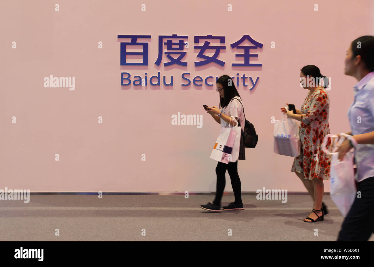 --FILE--Visitors walk past the stand of Baidu Security during an ...