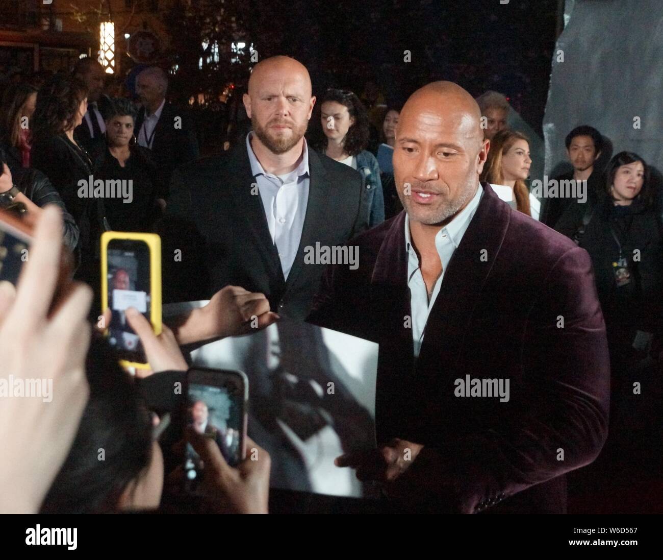 American actor Dwayne Johnson signs autographs for fans as he arrives ...