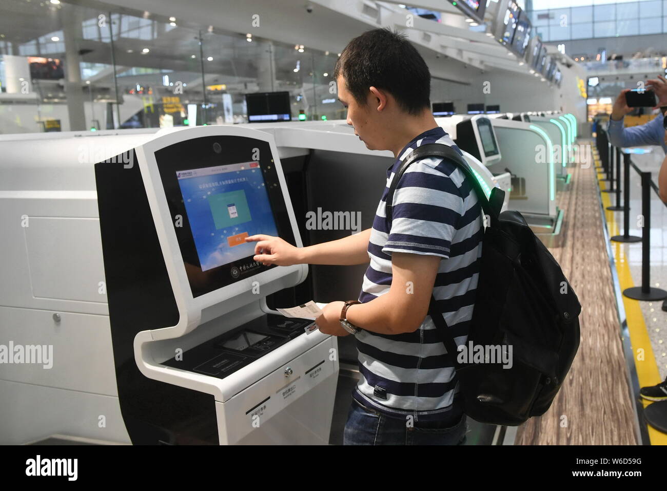 A passenger uses the self-baggage check-in machine at the Terminal 2 of ...